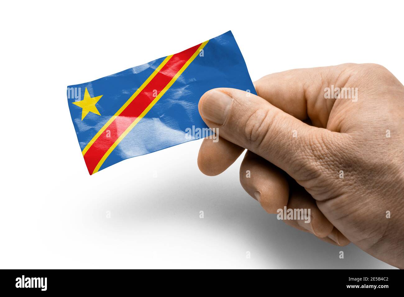 Hand holding a card with a national flag the Democratic Republic of the ...
