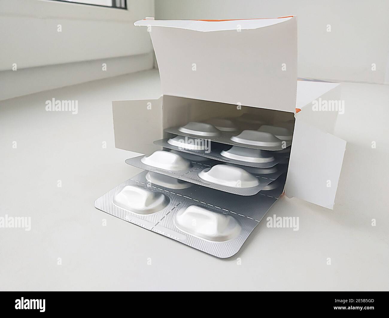 Paper packing with medical tablet rests upon window. Medication for ...