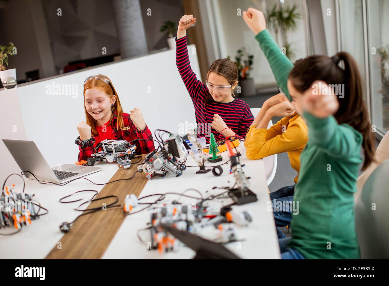 Group of happy kids programming electric toys and robots at robotics ...