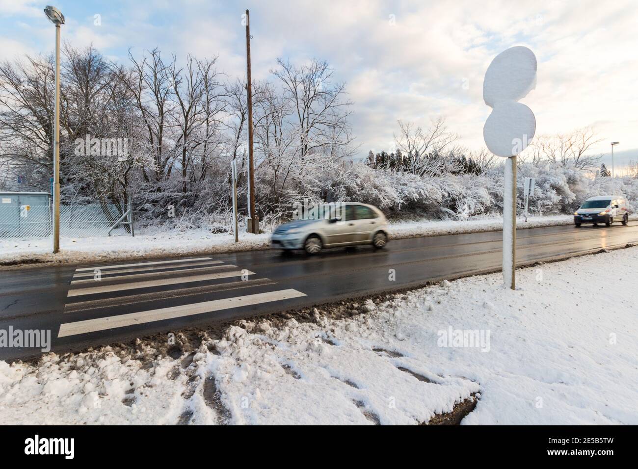 Traffic signs covered with snow beside road in winter, Sopron, Hungary ...