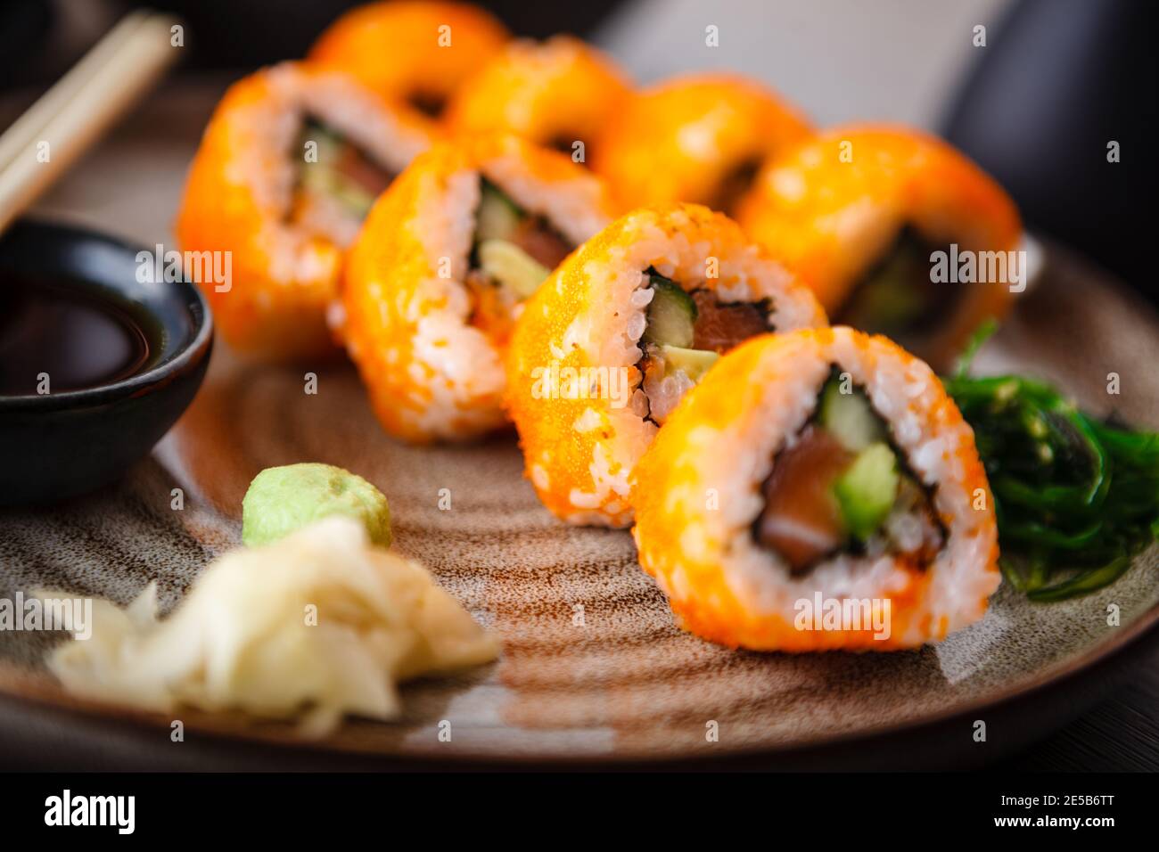 Sushi maki rolls with salmon, avocado, cucumber, flying fish roe on a ...