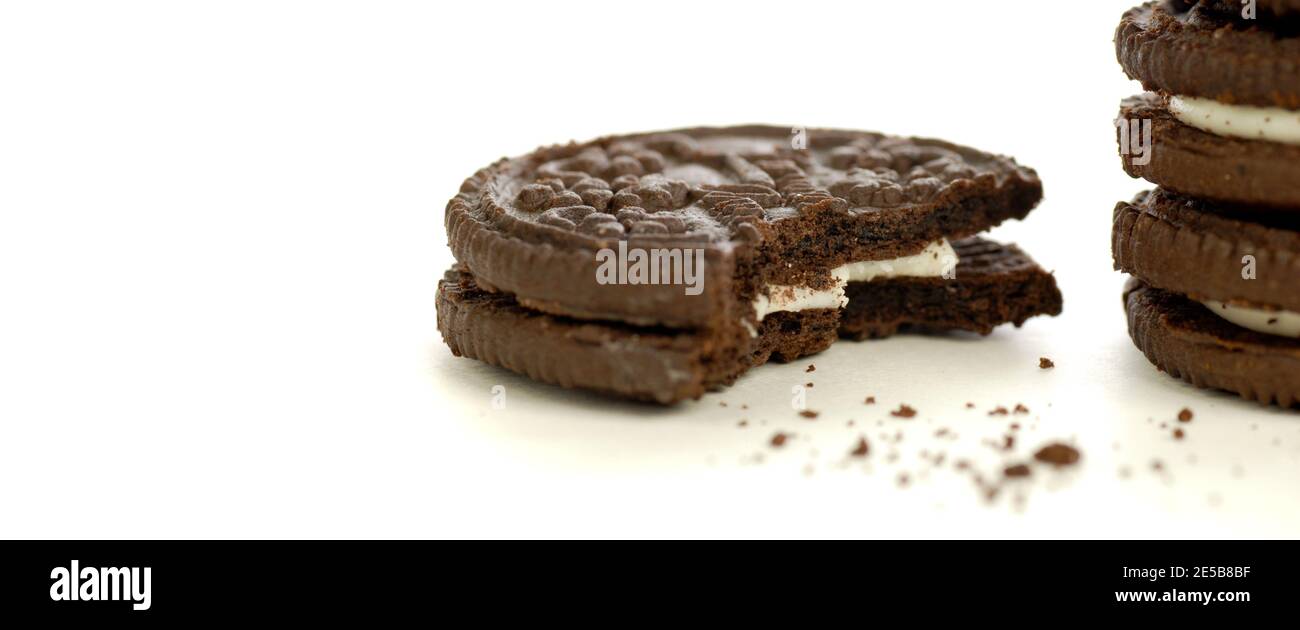 Chocolate cookies with creme filling and crumbs on white background ...