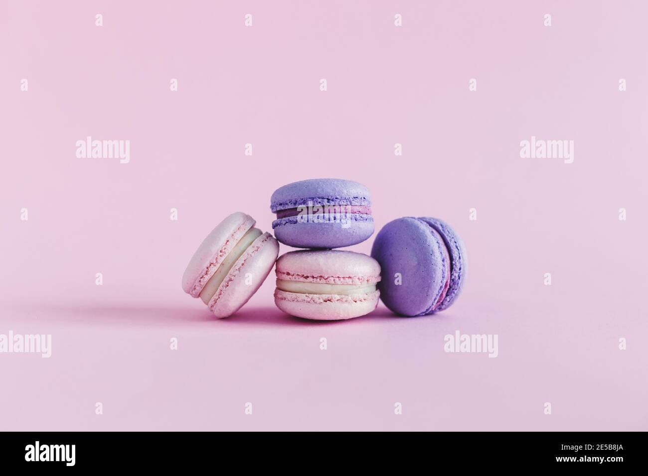 Tasty french macarons on a pink pastel background. Pink and violet ...