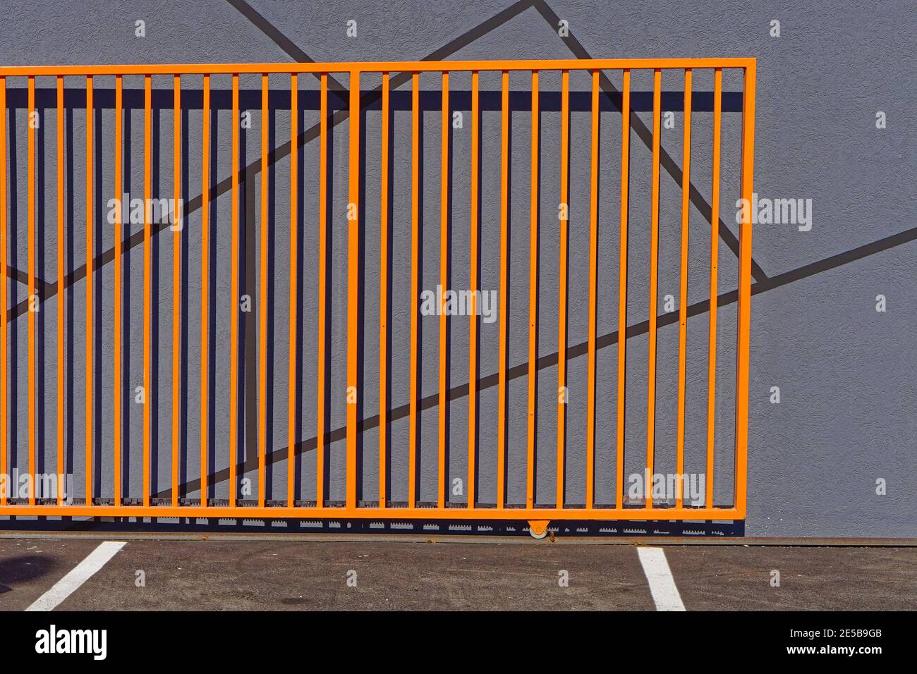Orange sliding metal fence gate at house Stock Photo - Alamy