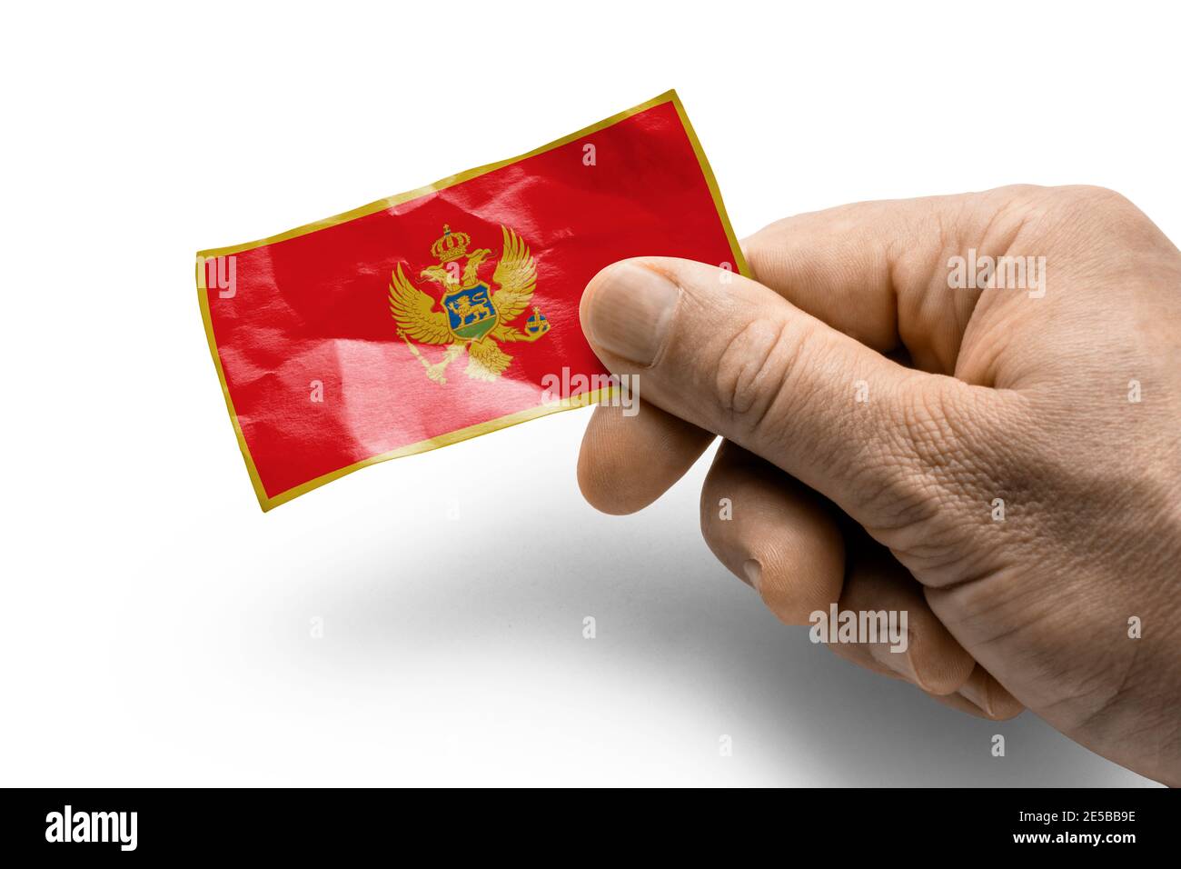 Hand holding a card with a national flag the Montenegro Stock Photo - Alamy