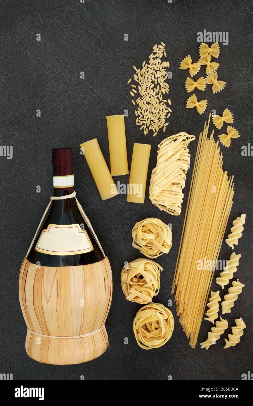 Assorted Italian pasta with traditional red wine wicker bottle on ...