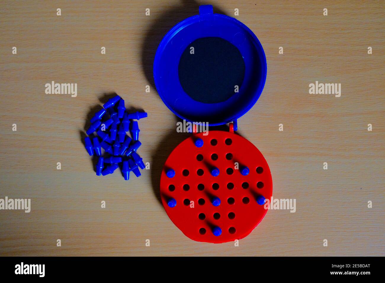 Solitaire game in bright blue and red plastic from above with no way of ...