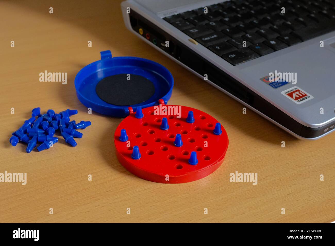 Solitaire game in bright blue and red plastic from above with no way of ...