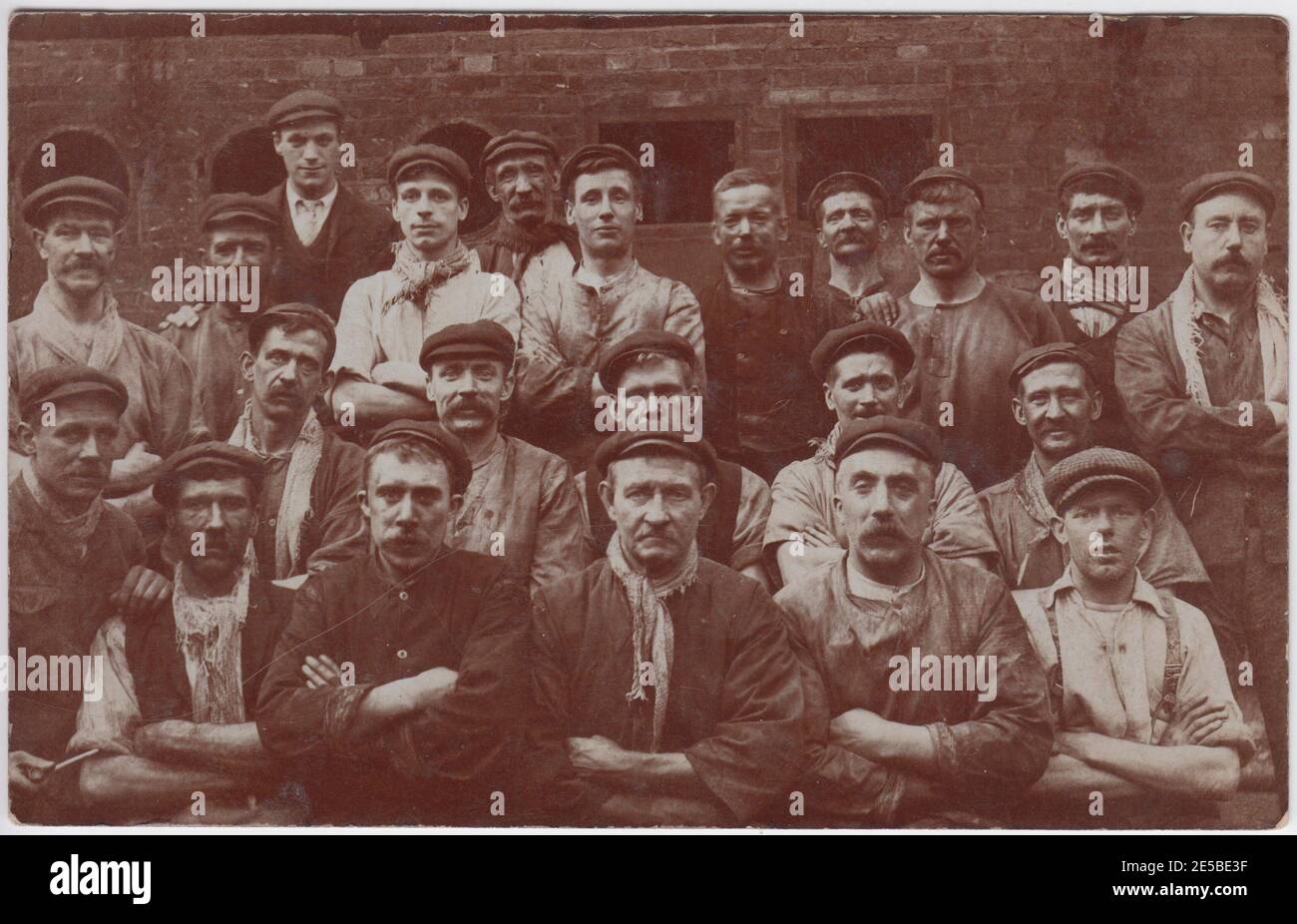 Group of industrial workers posing for the camera. Most are wearing ...