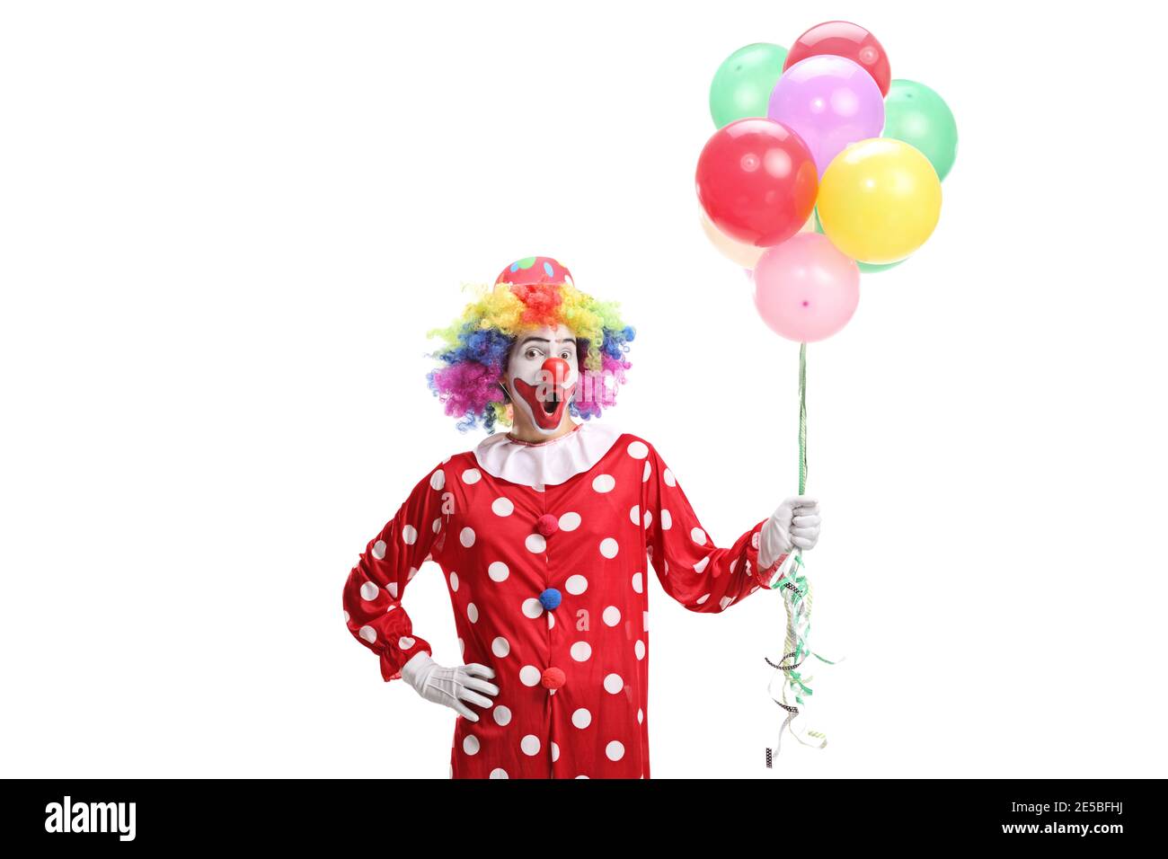 Surprised clown holding a bunch of balloons isolated on white ...