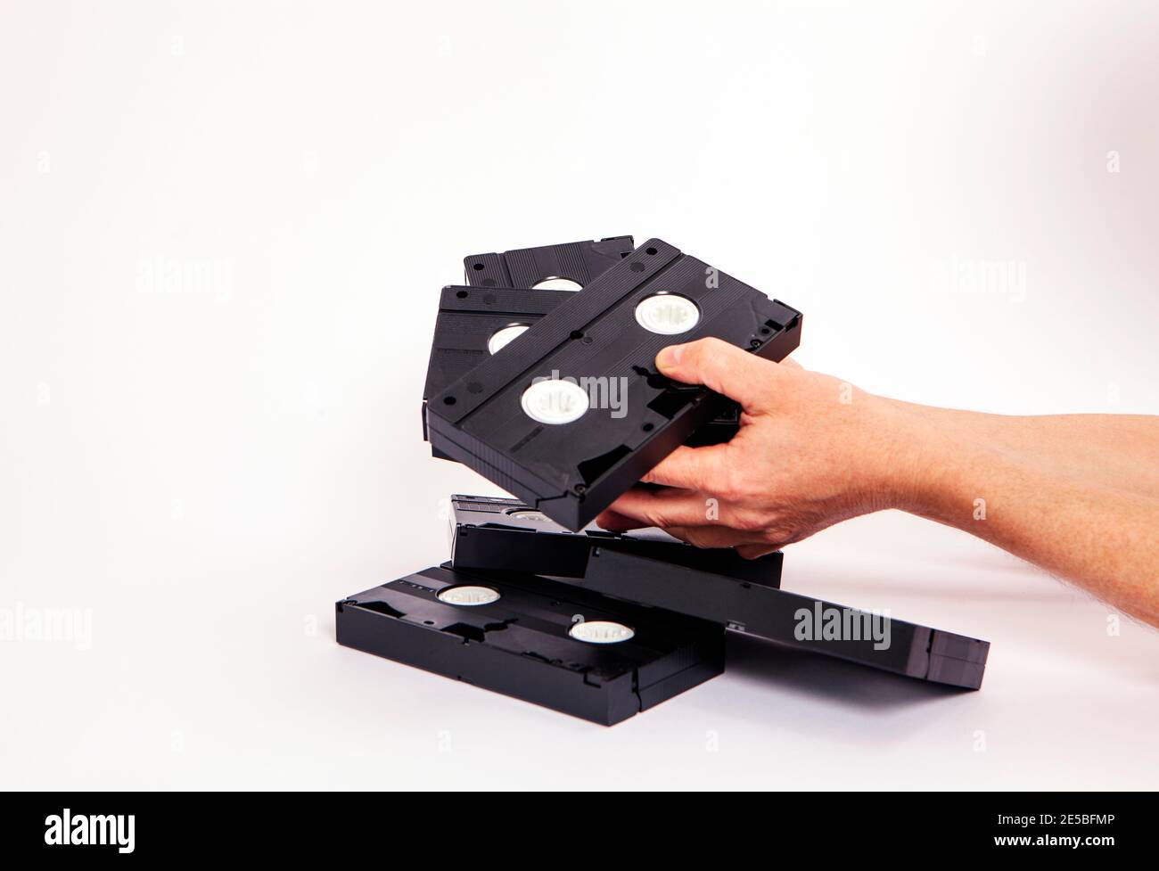 vhs videotapes black without boxes are stacked and in the hands on a ...