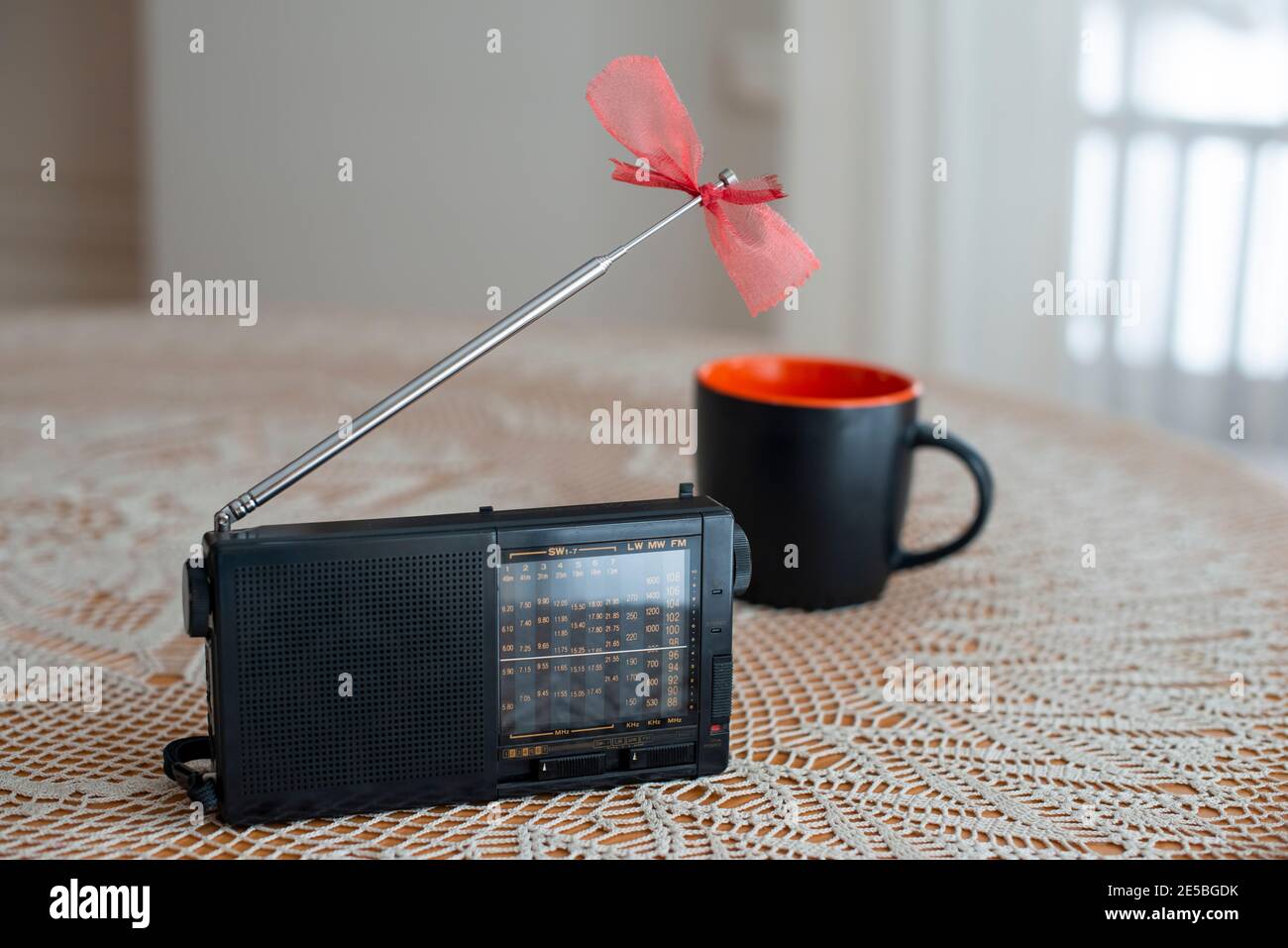 Vintage radio receiver with coffee cup on the table. World Radio Day ...