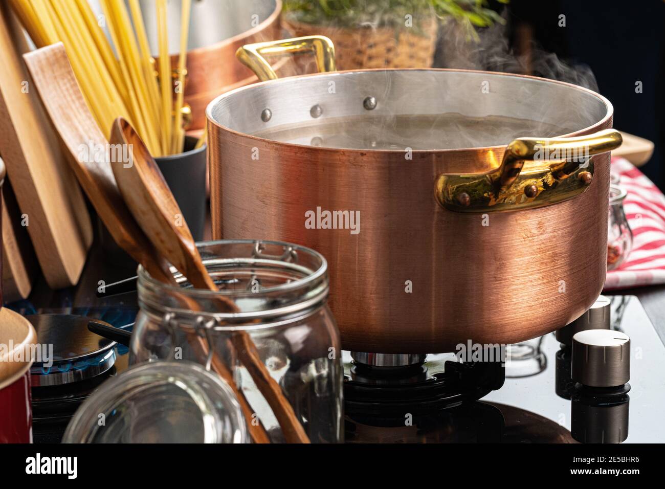 Copper pot with boiling water on a gas stove Stock Photo - Alamy