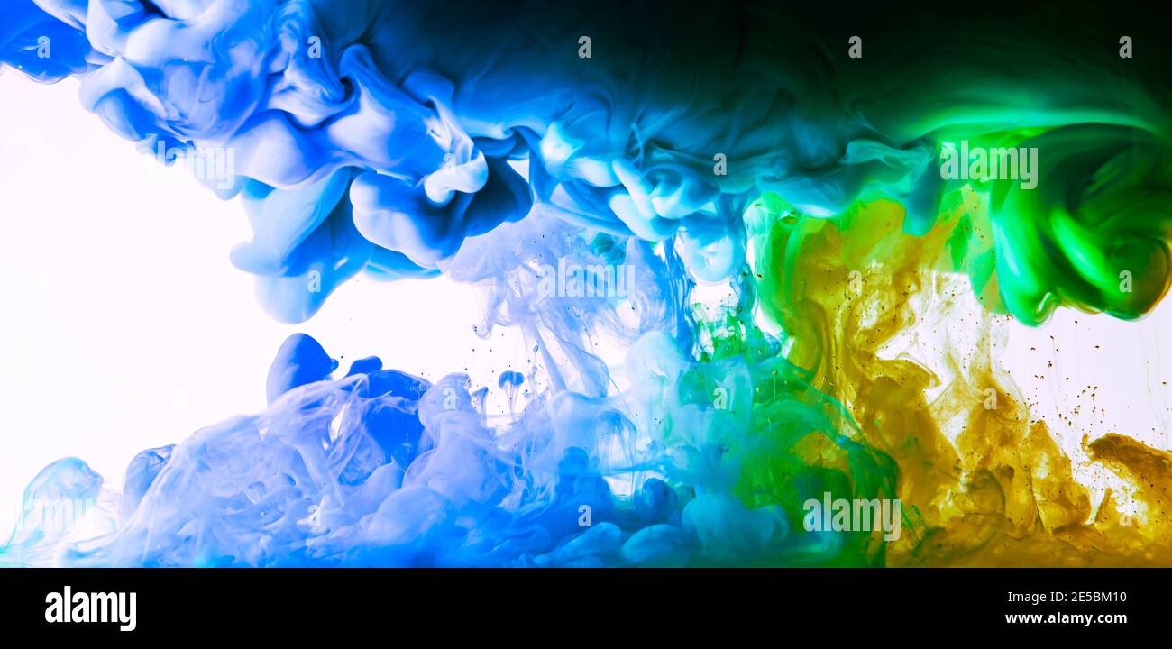Flowing blue, green and yellow ink in water. Abstract colorful ...