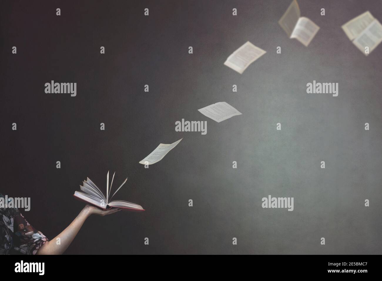 surreal moment of pages flying from a book held by a woman Stock Photo ...