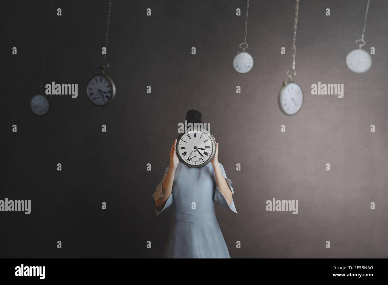 woman with face hidden by a clock in a room full of grandfather clocks ...