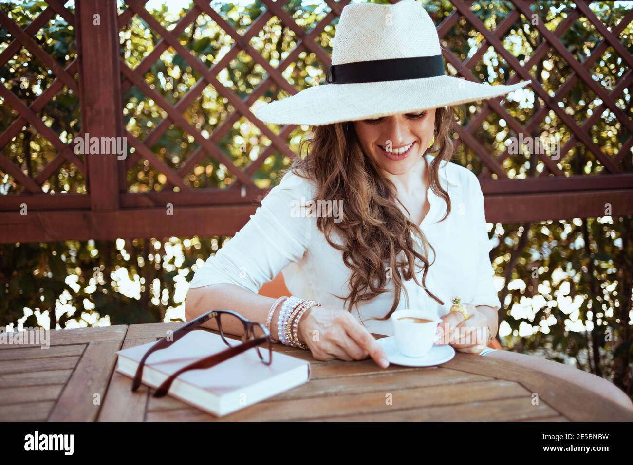 Beautiful woman sitting patio table hi-res stock photography and images ...