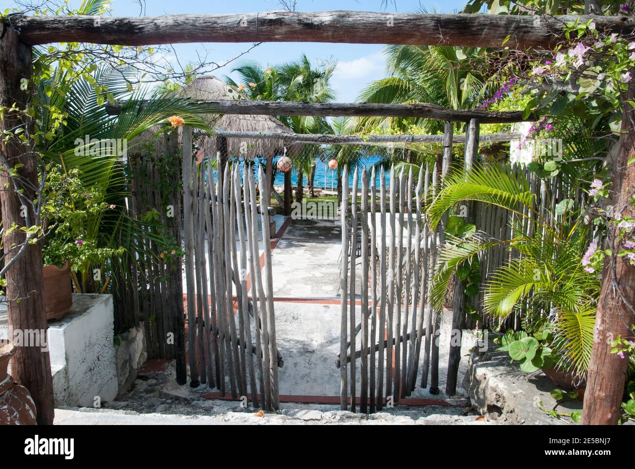 The traditional gate surrounded by lush tropical greenery in San Miguel ...