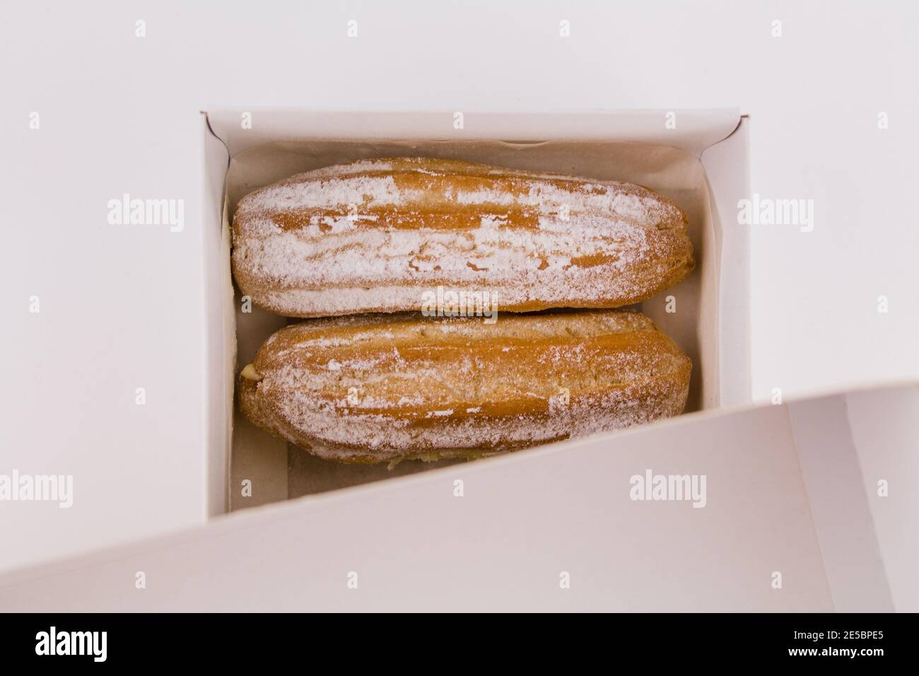 a delicious French eclairs in a box with powdered sugar Stock Photo - Alamy