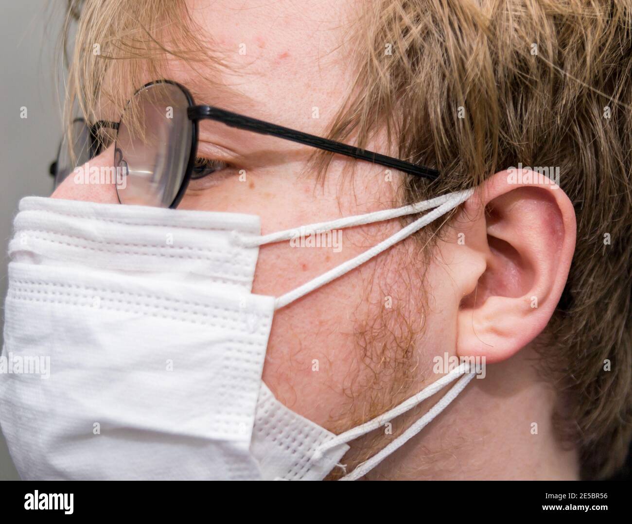Man wearing two white facemasks for Covid-19 prevention; Round ...