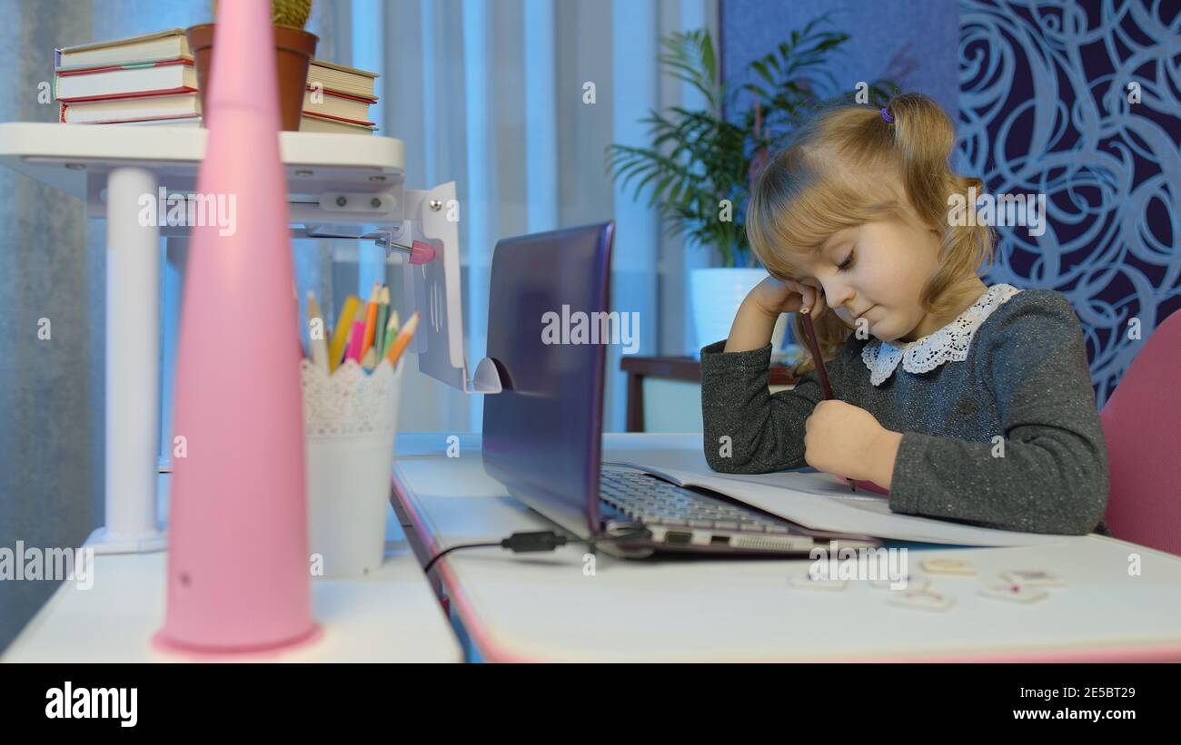Preschool child girl distance online learning at home. Bored kid ...