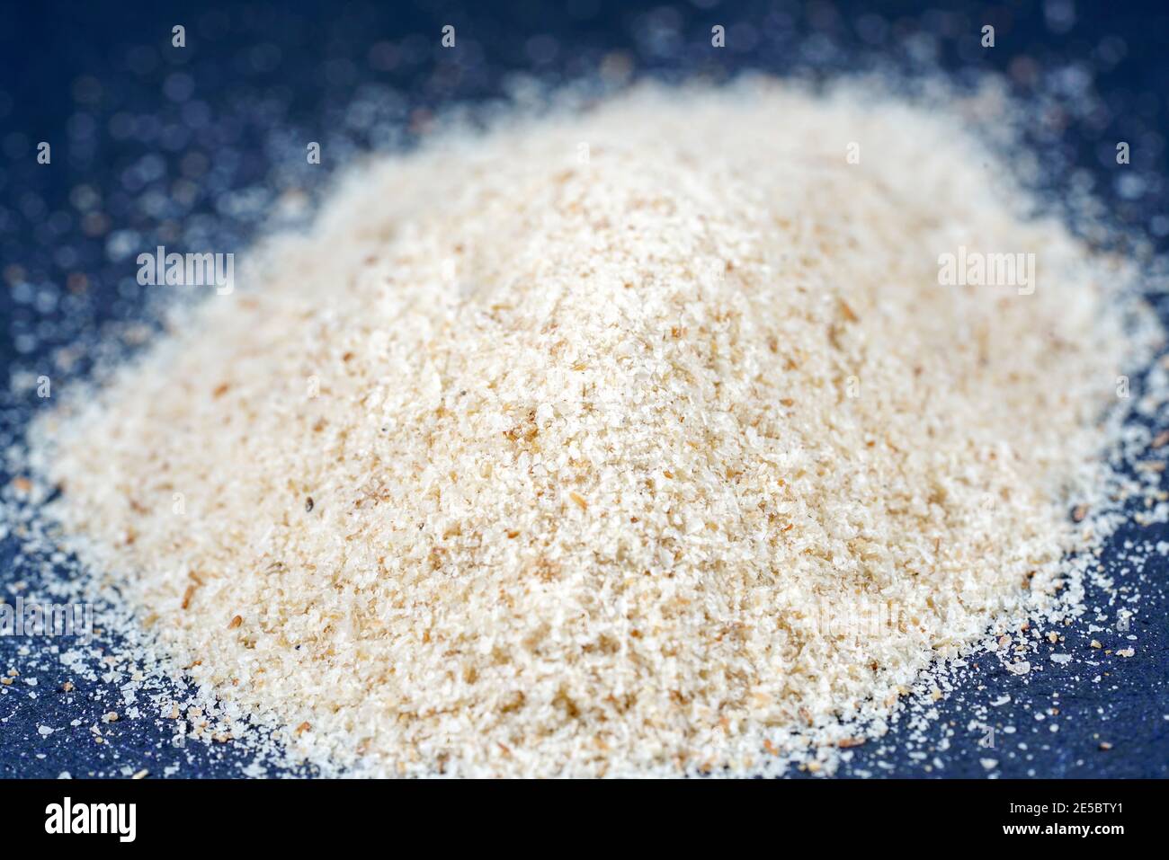 Ground Indian flea seeds photographed in the studio against a black ...