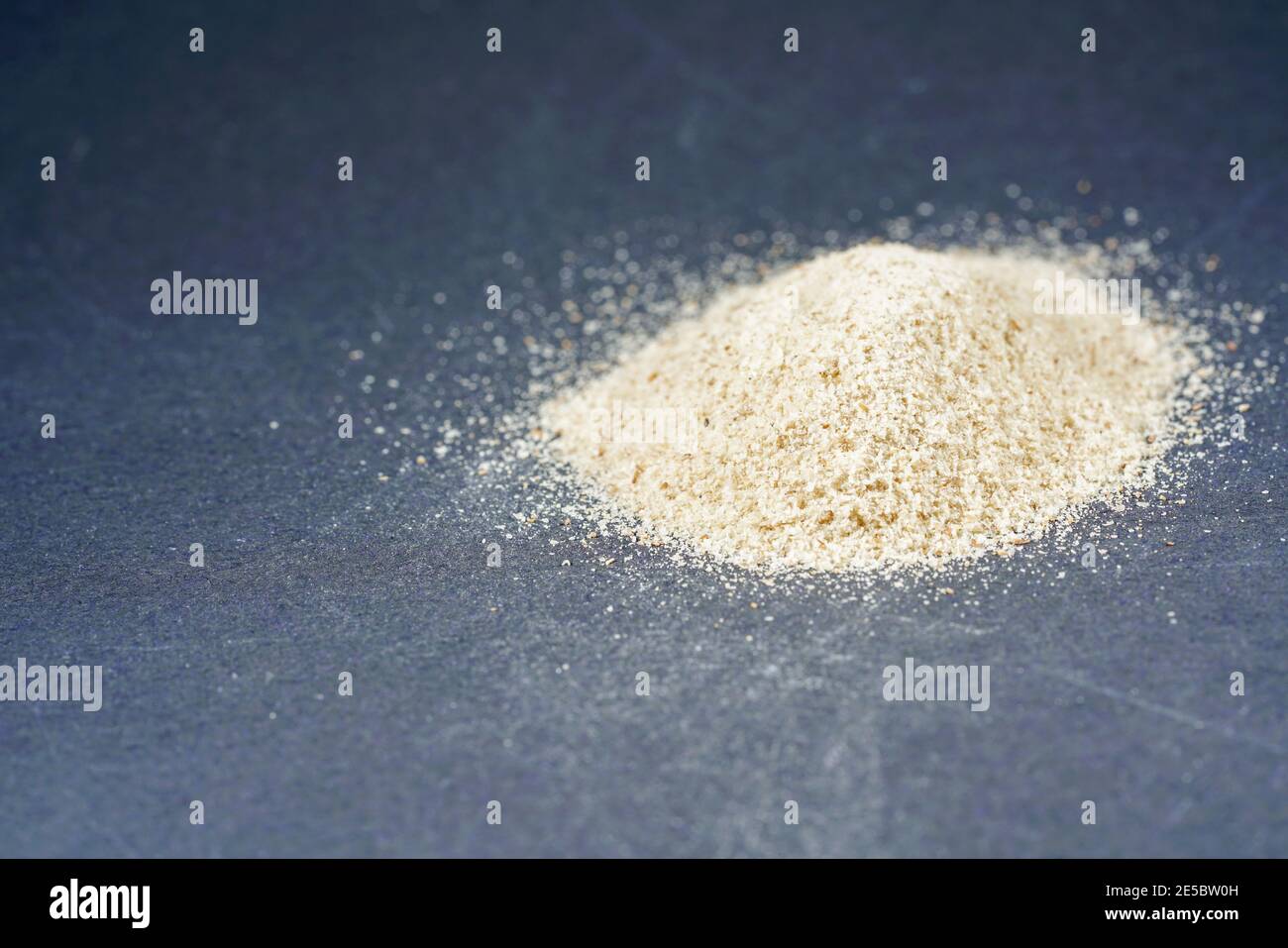 Ground Indian flea seeds photographed in the studio against a black ...