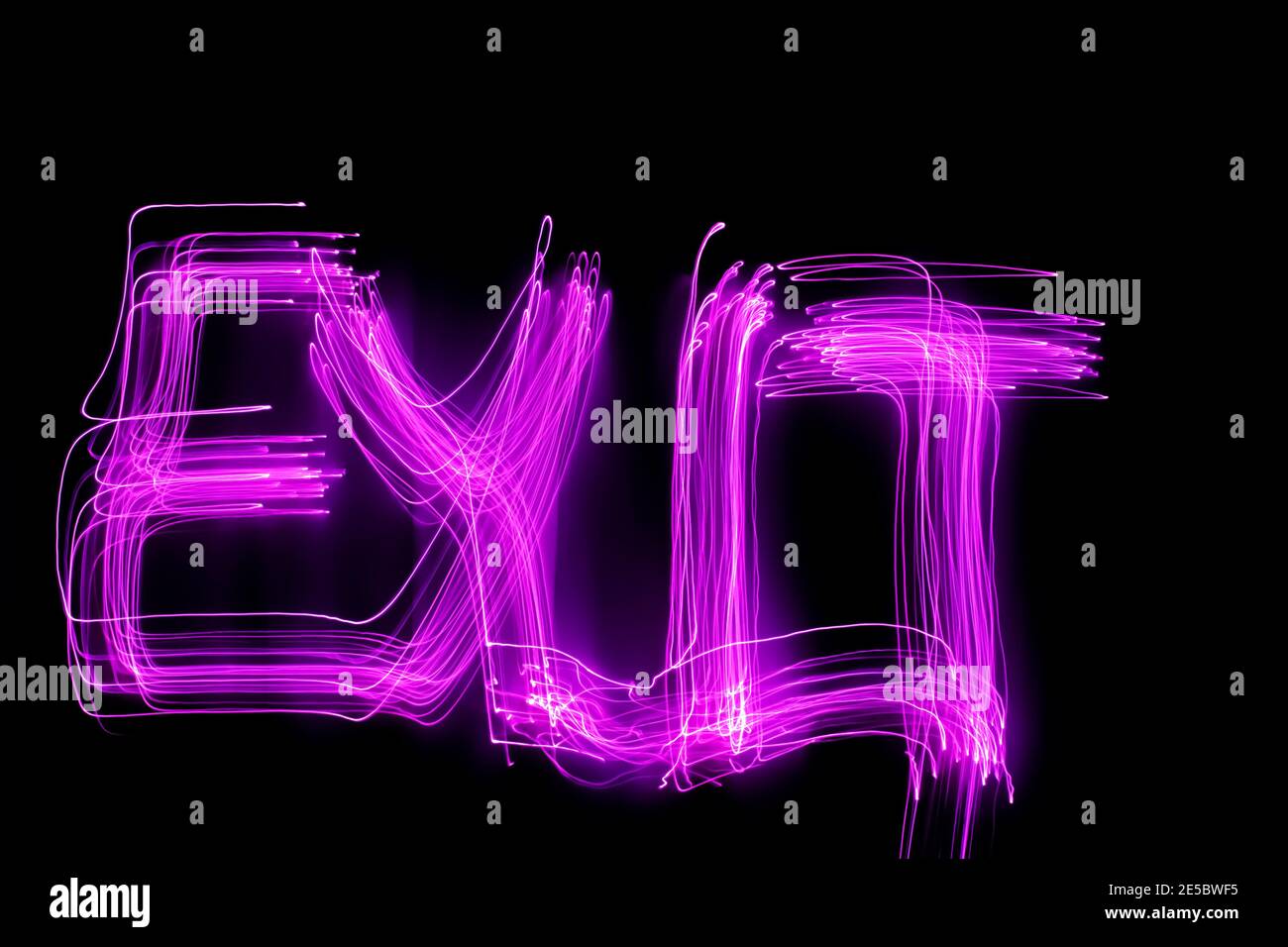 'Exit' word written in pink light on black background. Long exposure ...