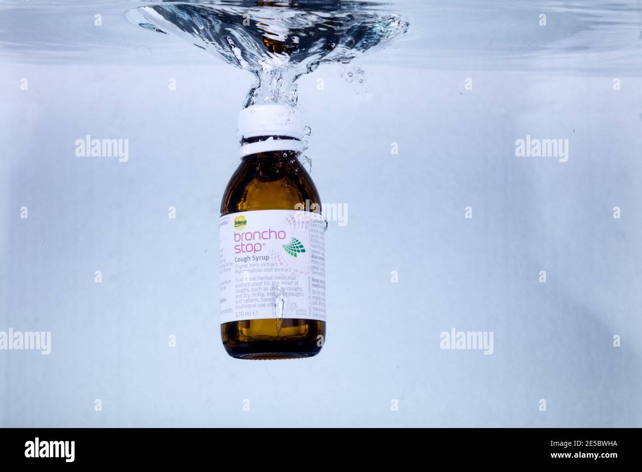 Hi-speed shot of a bottle of Bronchostop cough syrup dropping into ...