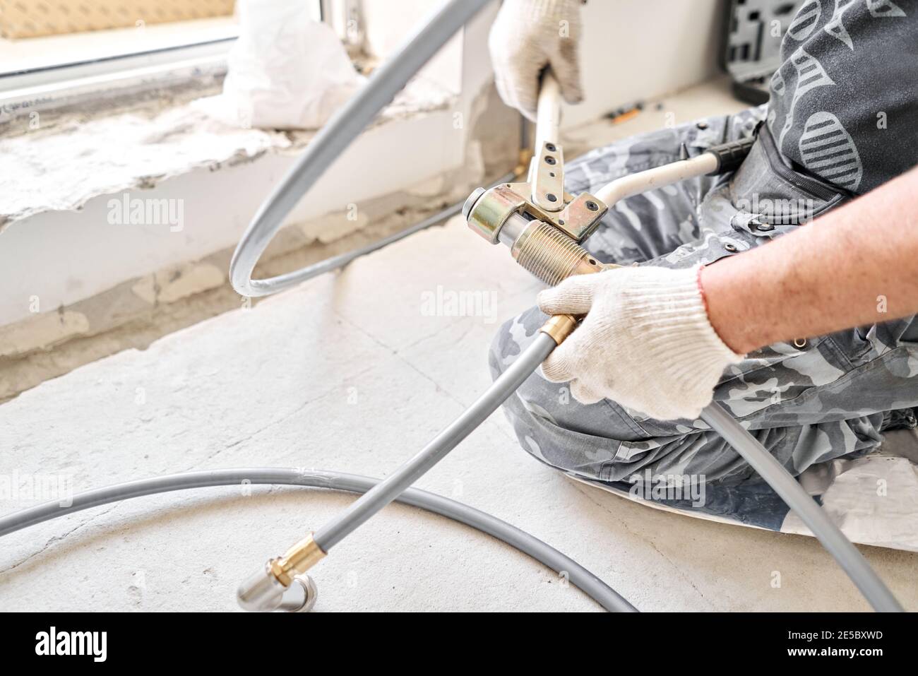 connection heating pipes to white Radiator in a new apartment under ...