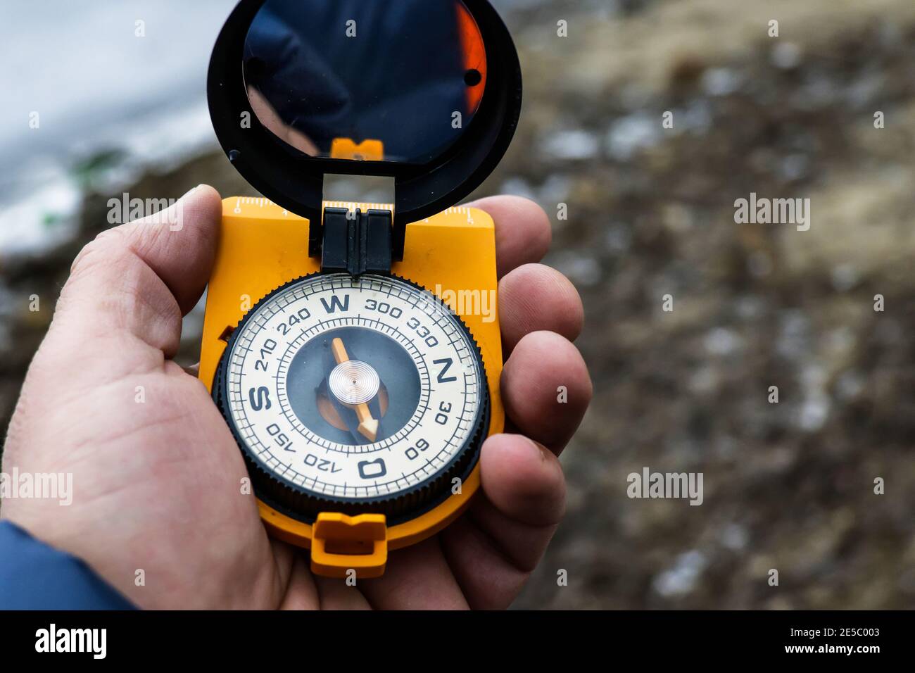 Compass in hand. Navigation on the terrain using a magnetic compass ...