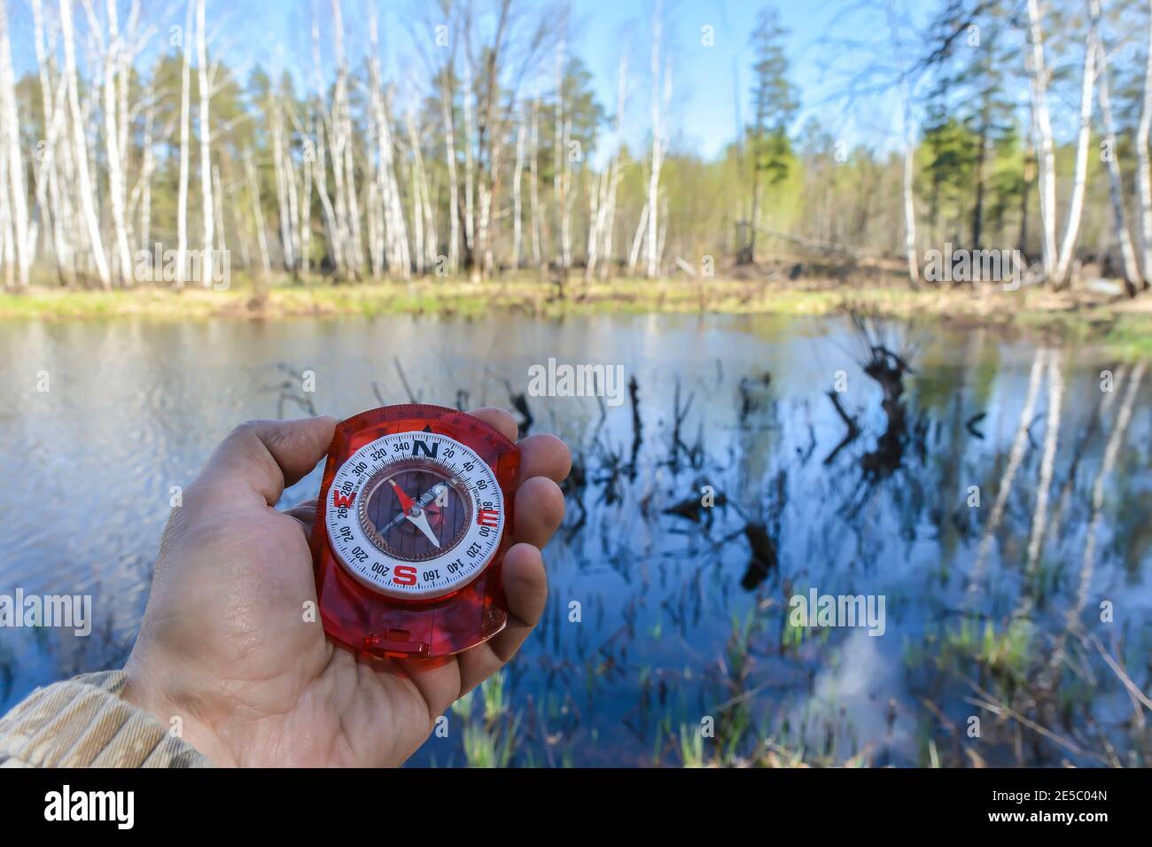 Compass in hand. Navigation on the terrain using a magnetic compass ...