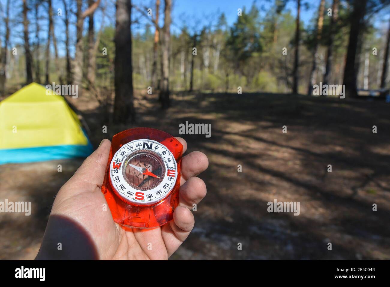 Compass in hand. Navigation on the terrain using a magnetic compass ...