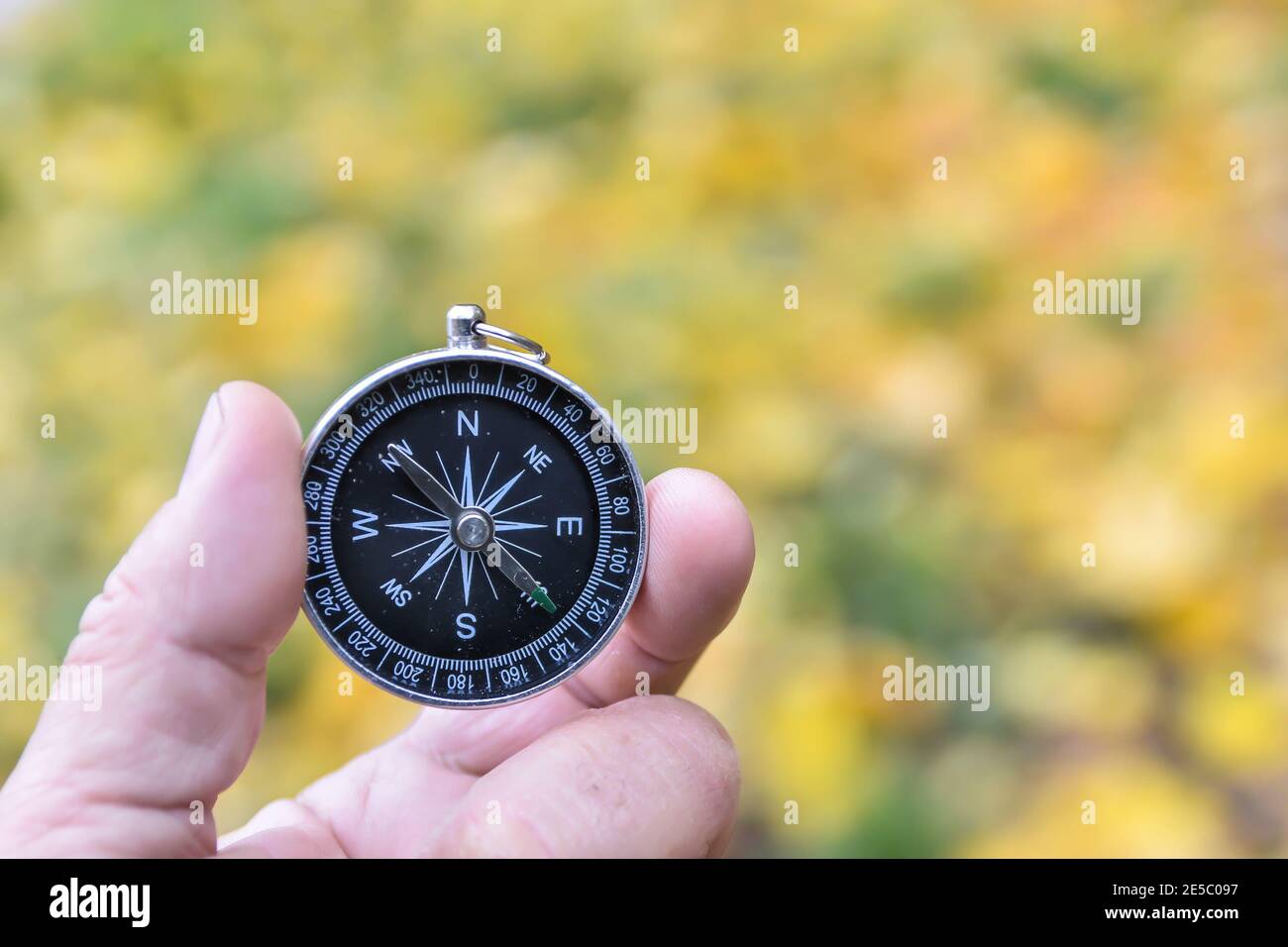 Compass in hand. Navigation on the terrain using a magnetic compass ...
