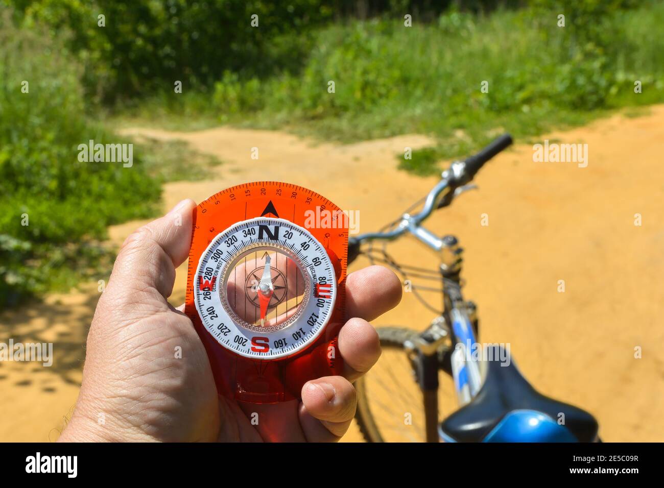 Compass in hand. Navigation on the terrain using a magnetic compass ...