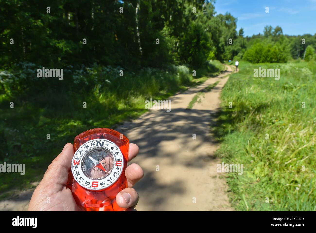Compass in hand. Navigation on the terrain using a magnetic compass ...