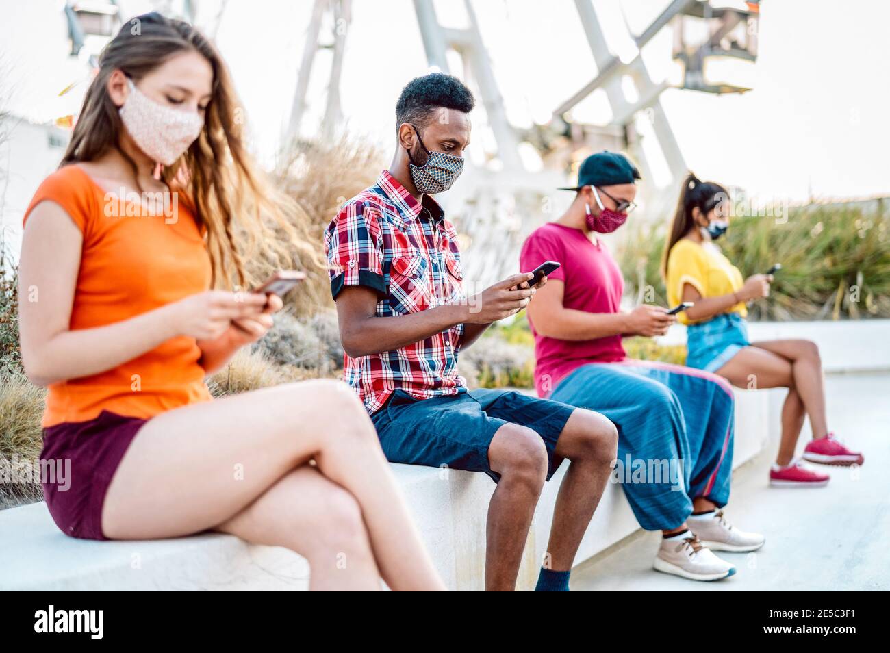 Multicultural friends with surgical mask using tracking app on mobile ...