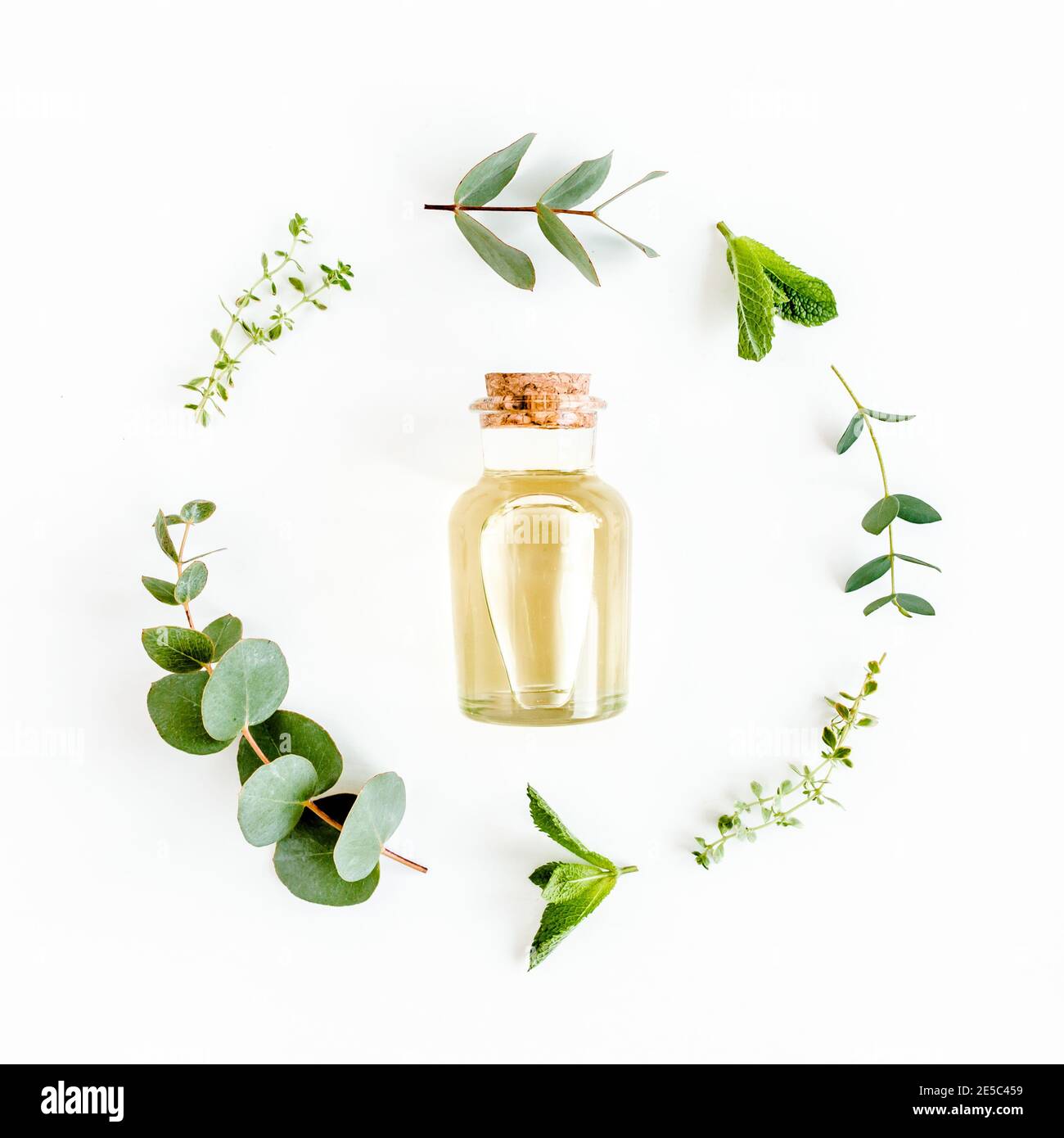 Essential oil and round wreath frame made of mix of herbs, green ...