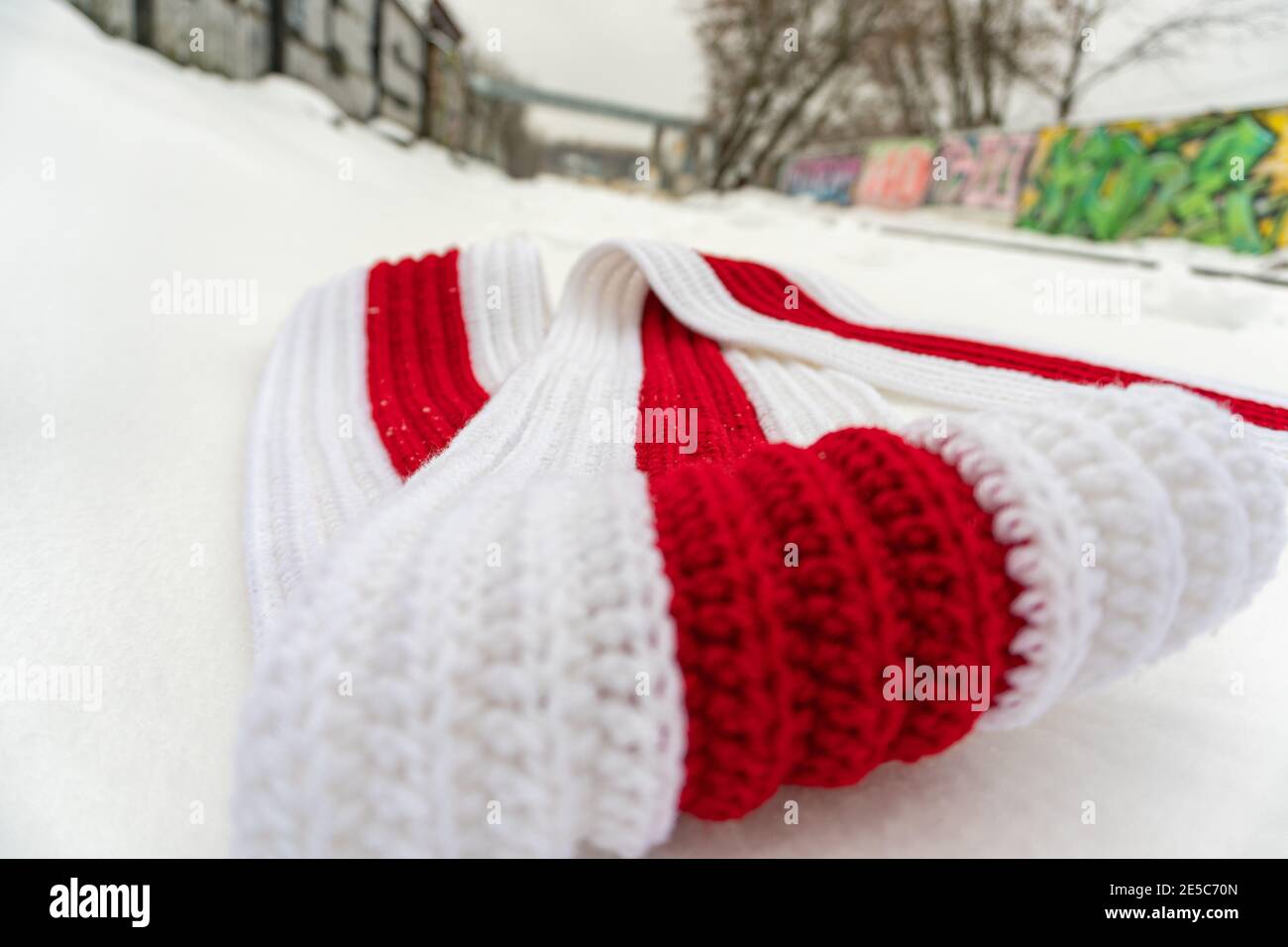 White-red-white knitted scarf on snow on the street Stock Photo - Alamy
