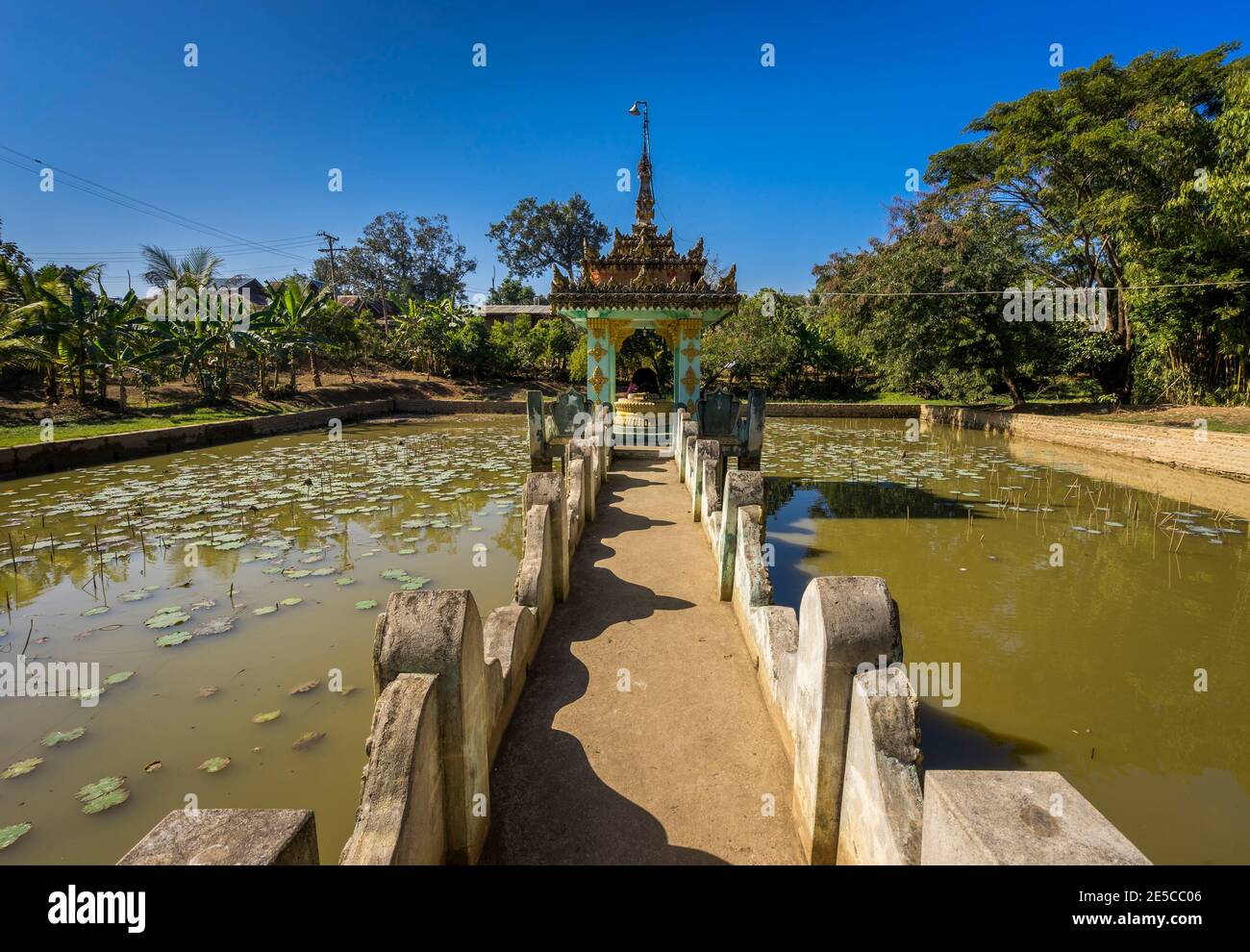 Bridge leading to Buddhist shrine on lake at Maha Nanda Kantha Stock ...