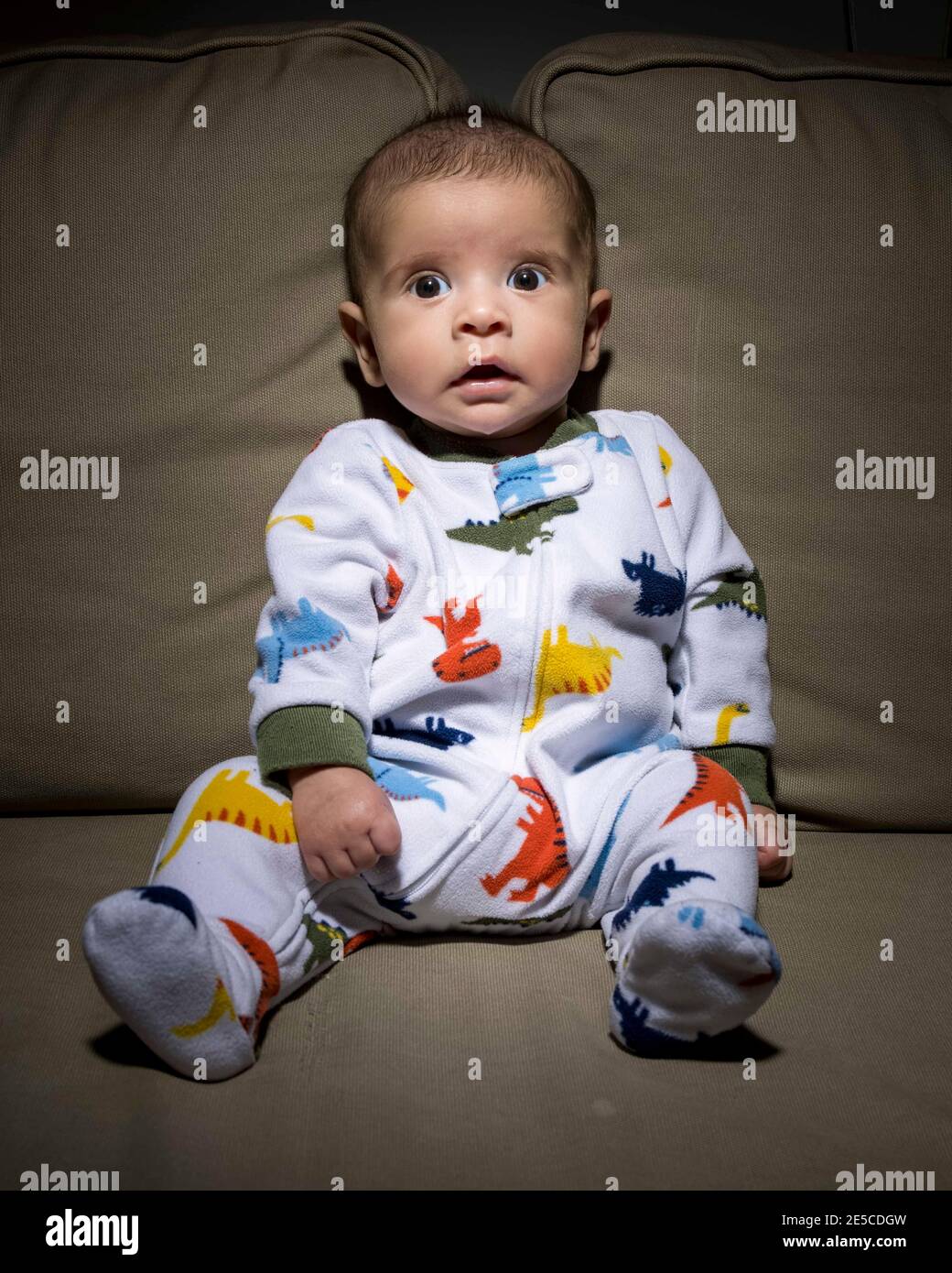 Funny infant sitting on couch Stock Photo - Alamy