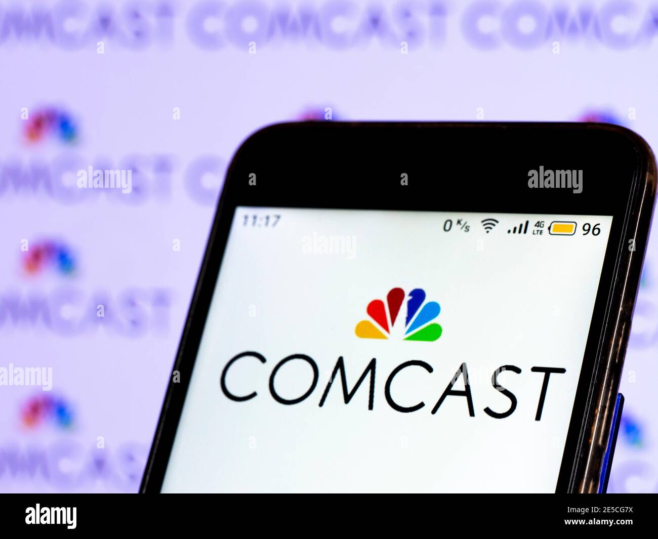 In this photo illustration a Comcast logo seen displayed on a ...