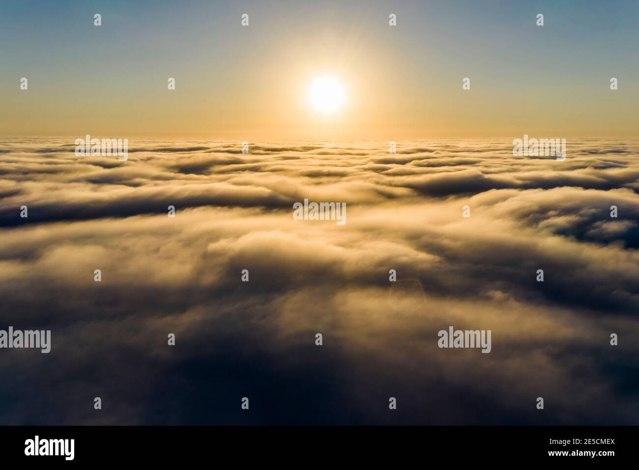 Striking aerial view of the sunset sky with the clouds below us. The ...