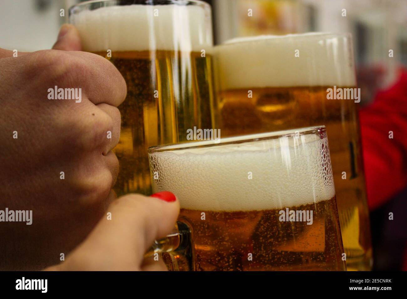 three people cheering with beer Stock Photo - Alamy