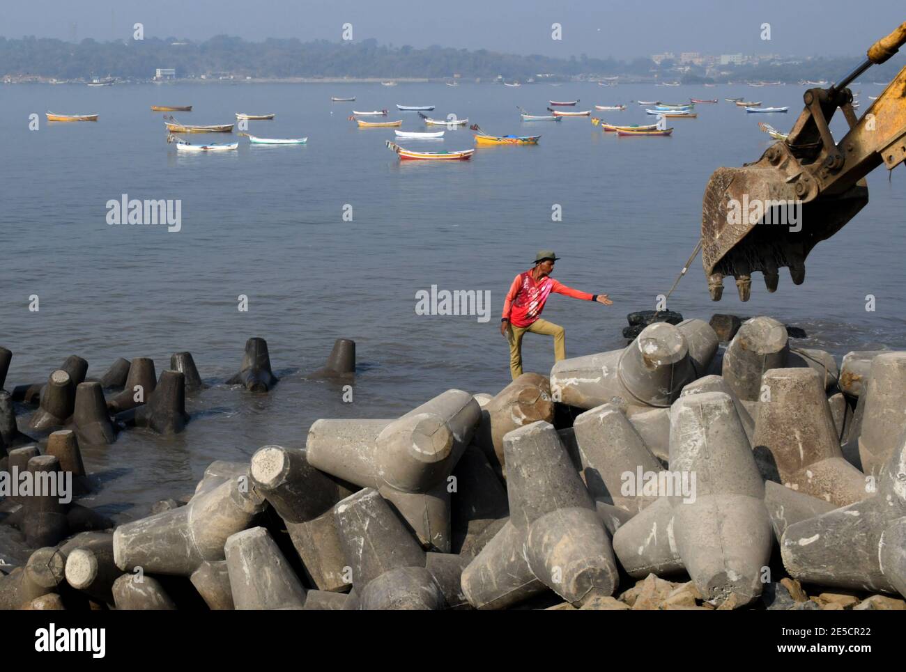 A labourer stands on a tetrapod during the tetrapod rock arrangement ...