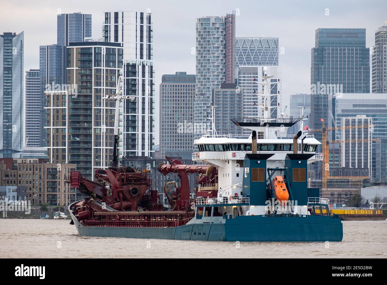 Ship sailing on river Thames past Canary Wharf, London, England, UK ...