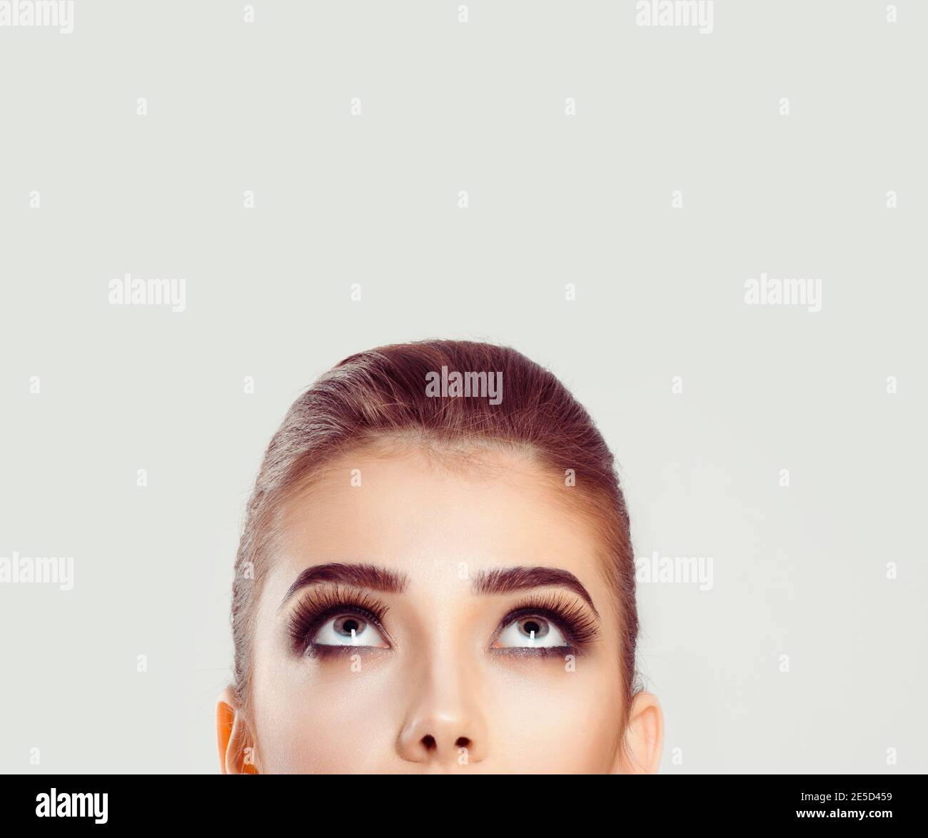 Young woman looking up upwards seeing something interesting isolated on ...