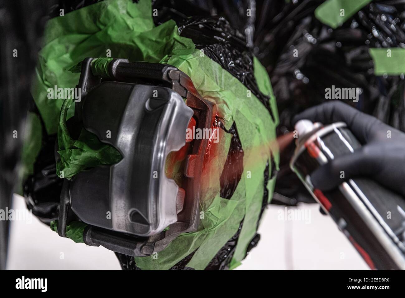 Mechanic painting brake calipers with red paint Stock Photo - Alamy