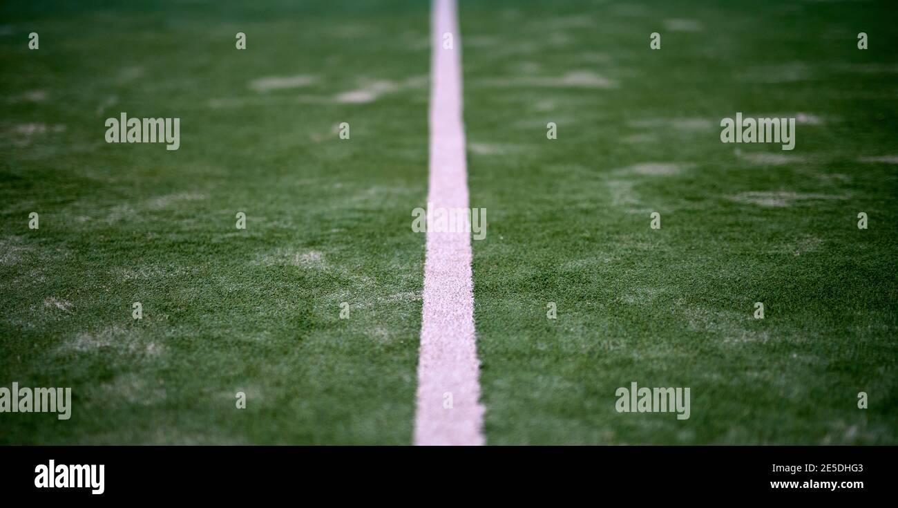 white line detail painted on green artificial synthetic grass with sand ...