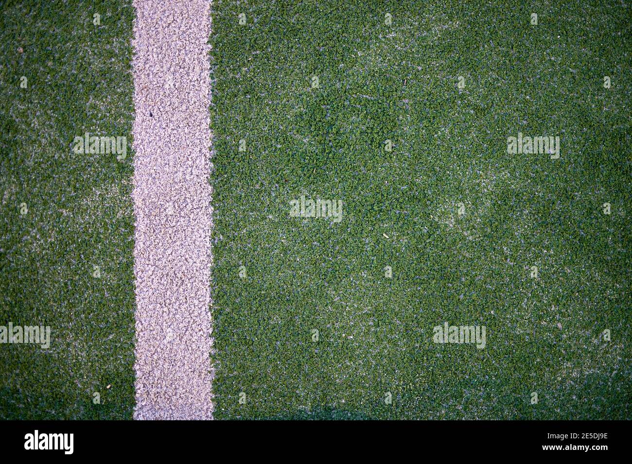 white line detail painted on green artificial synthetic grass with sand ...